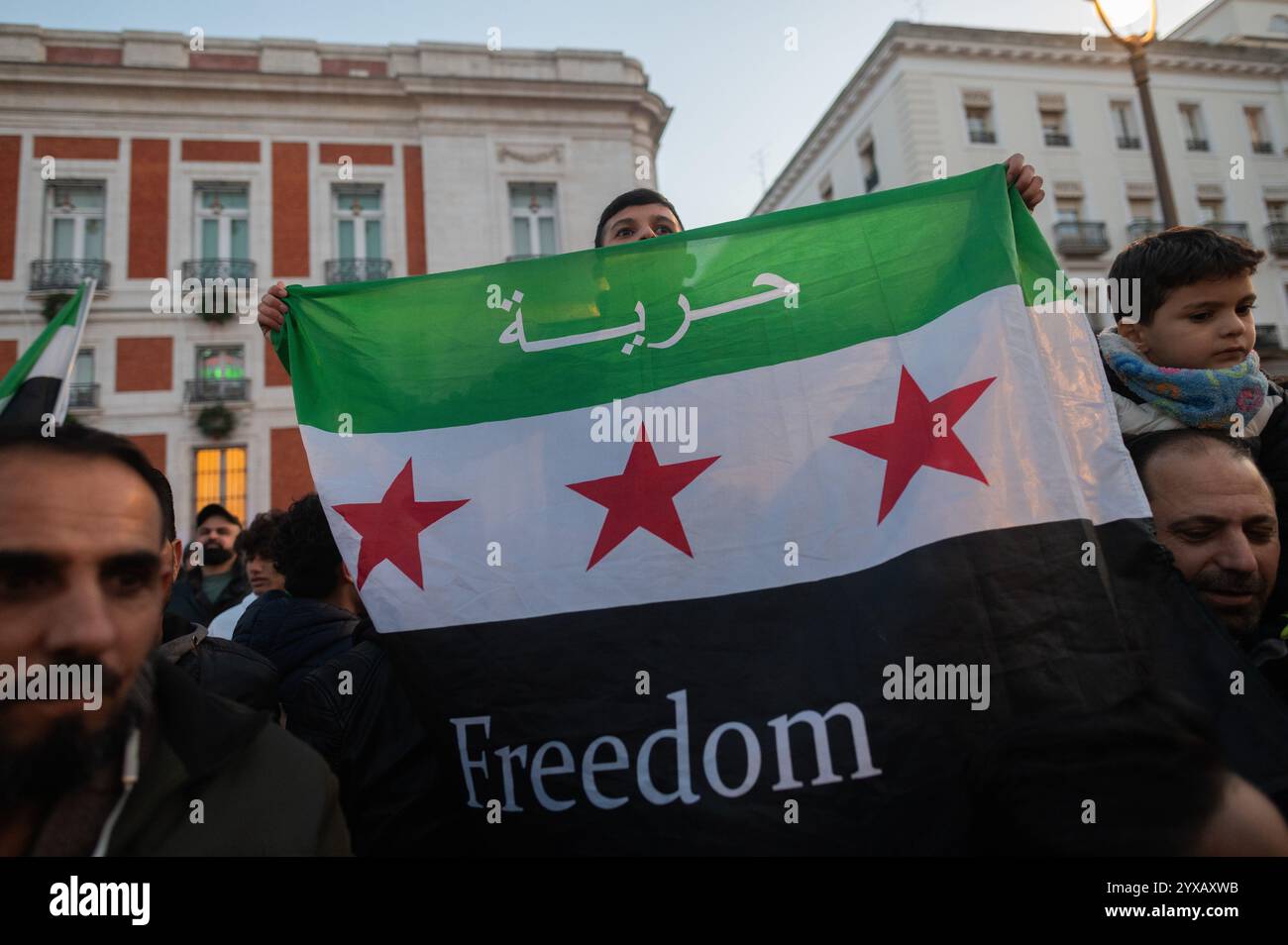 Madrid, Spain. 14th Dec, 2024. A man holds the Syrian Rebel flag during ...