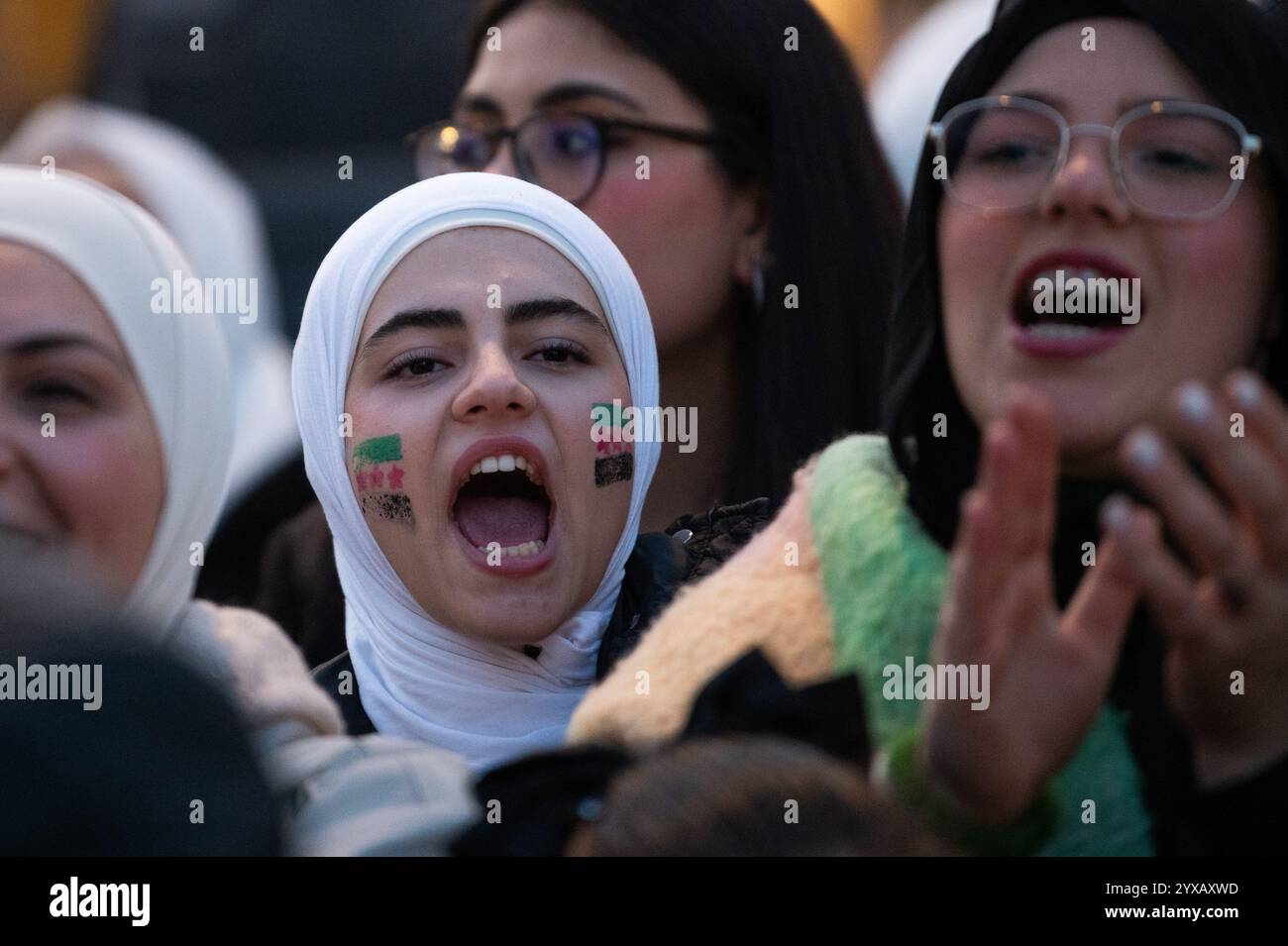 Madrid, Spain. 14th Dec, 2024. A woman with Syrian Rebel flags painted ...
