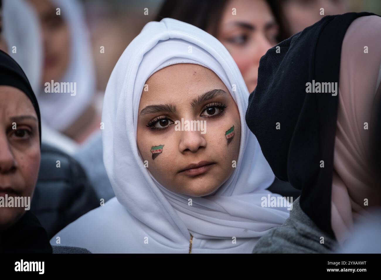 A woman with Syrian Rebel flags painted on her face during a ...