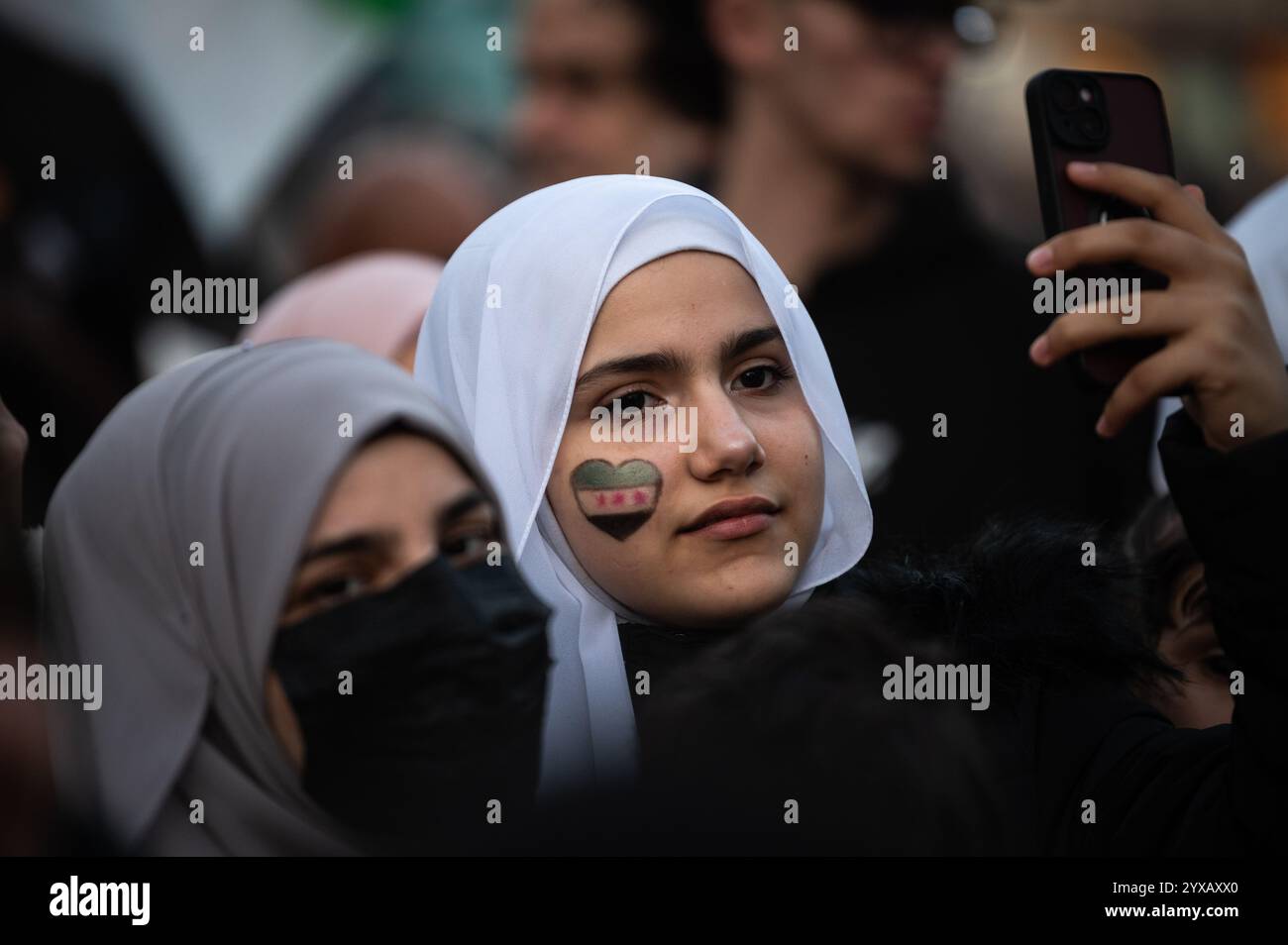 Madrid, Spain. 14th Dec, 2024. A woman with Syrian Rebel flags painted ...