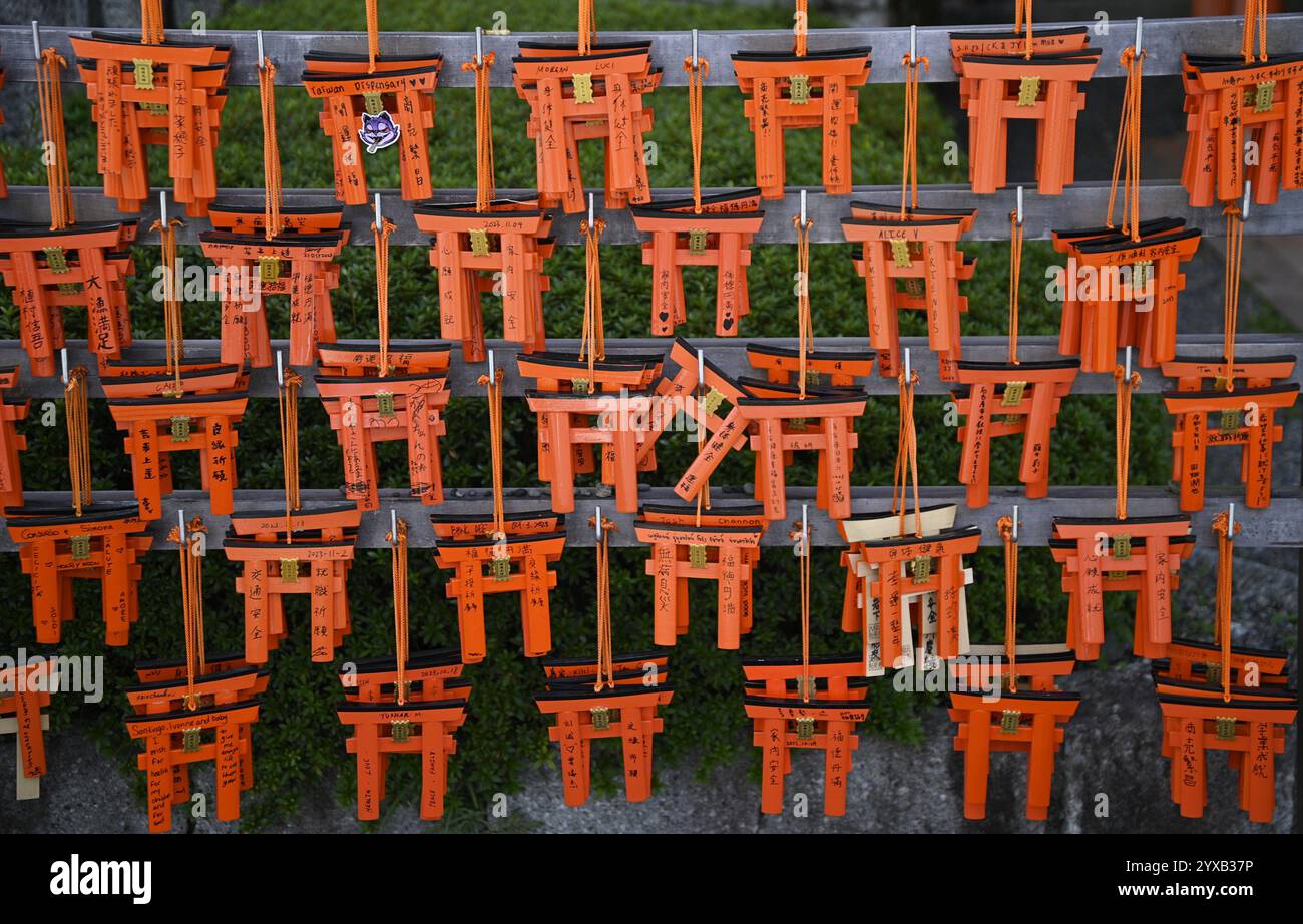 Offerings of miniature vermilion torii gates on the grounds of the ...