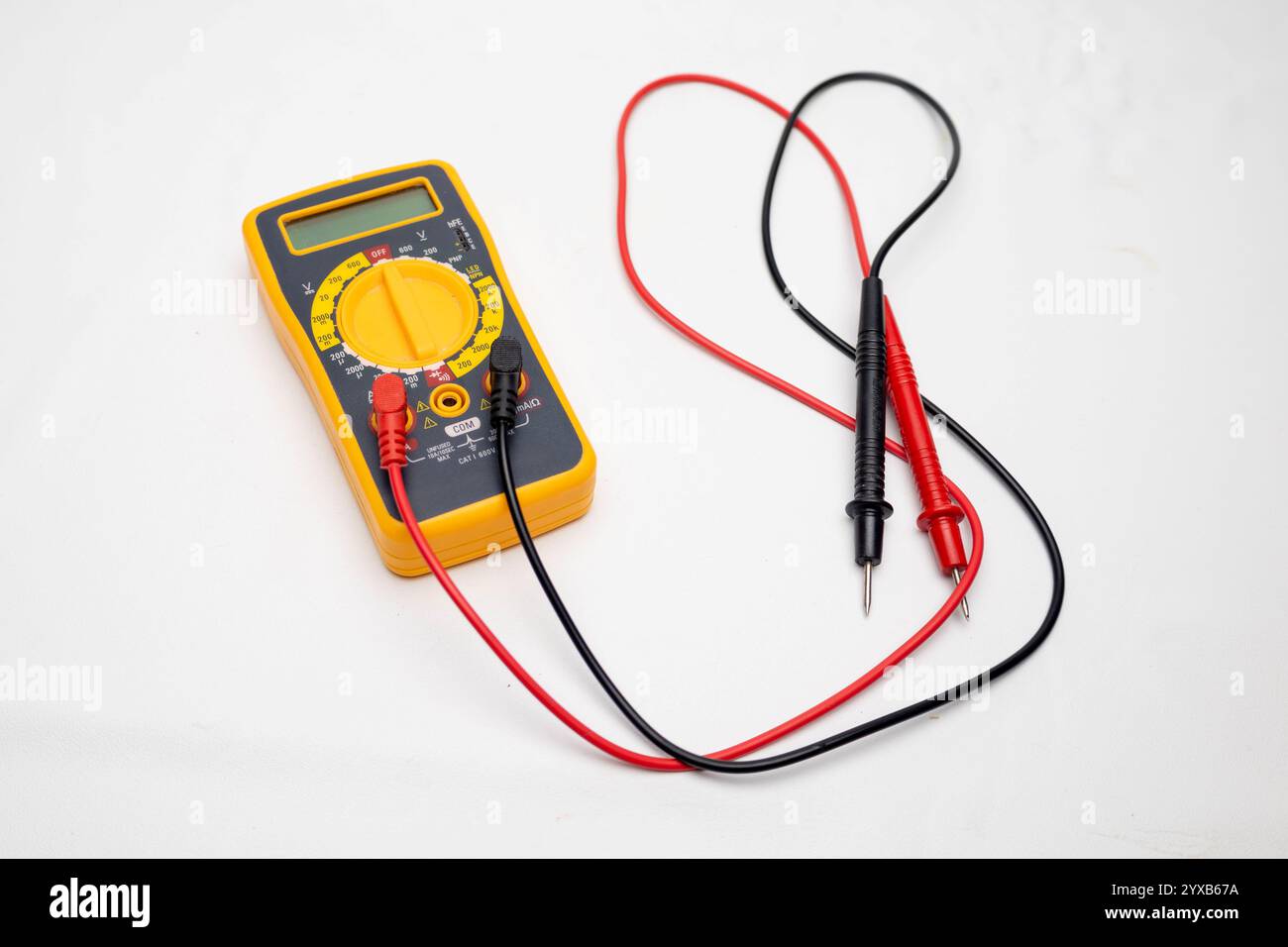Yellow and gray multimeter with red and black probes for measuring ...