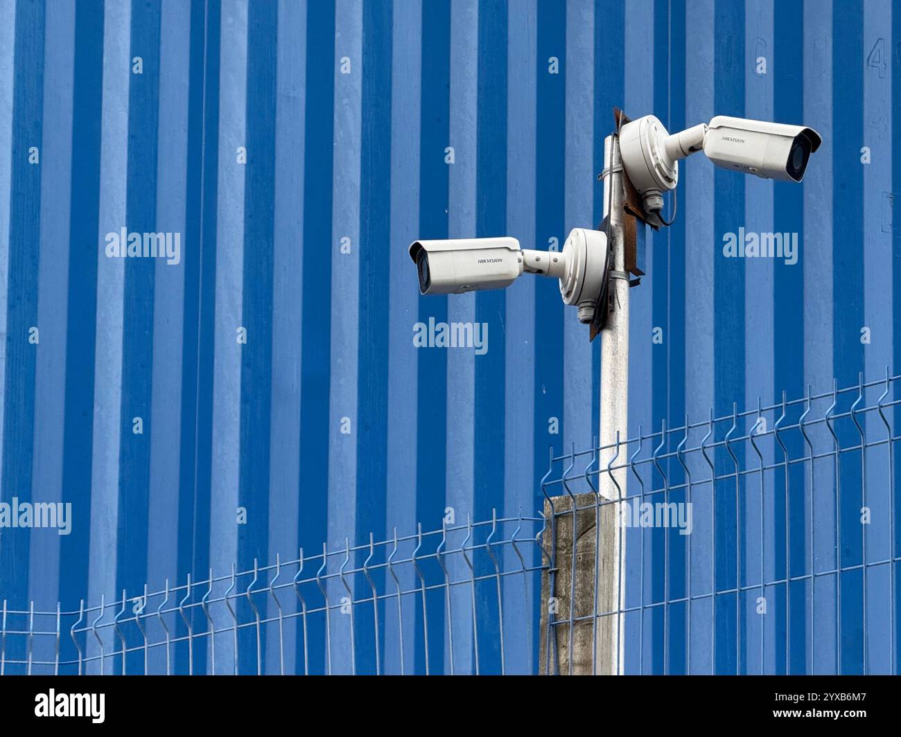 Security cameras on building site against blue shipping container ...