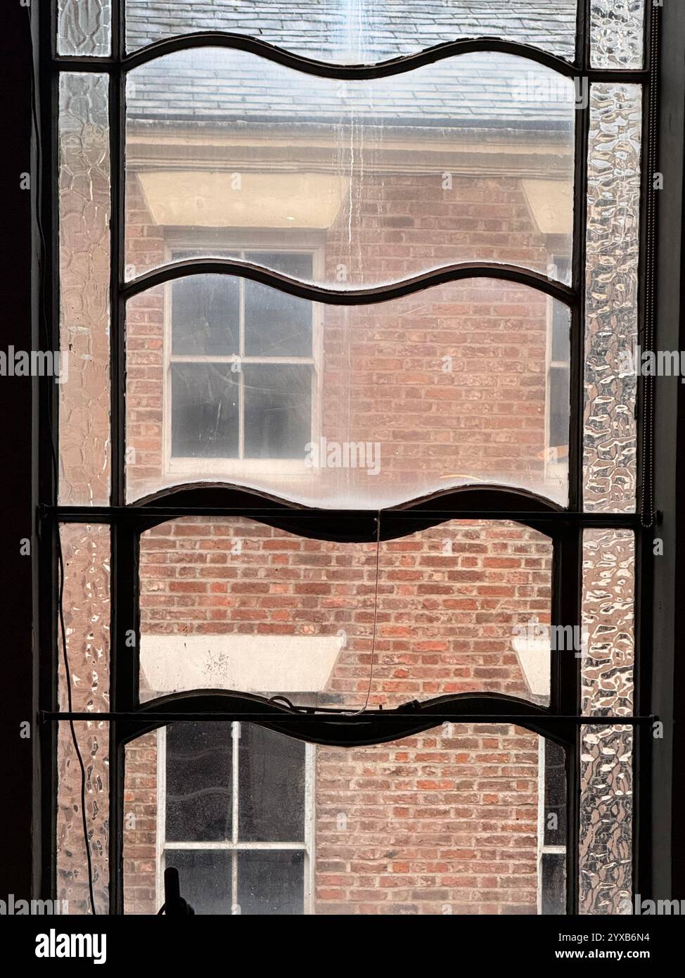 Terrace house sash windows viewed through decorative leaded window ...