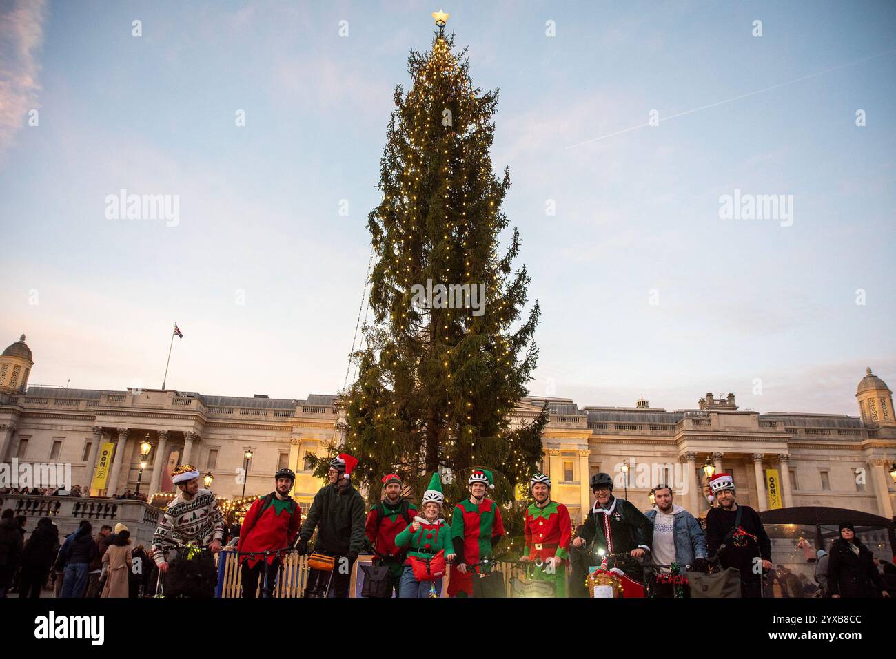 London, UK. 14th Dec, 2024. A group of bicyclists dressed as elves poses for photo front of the ...