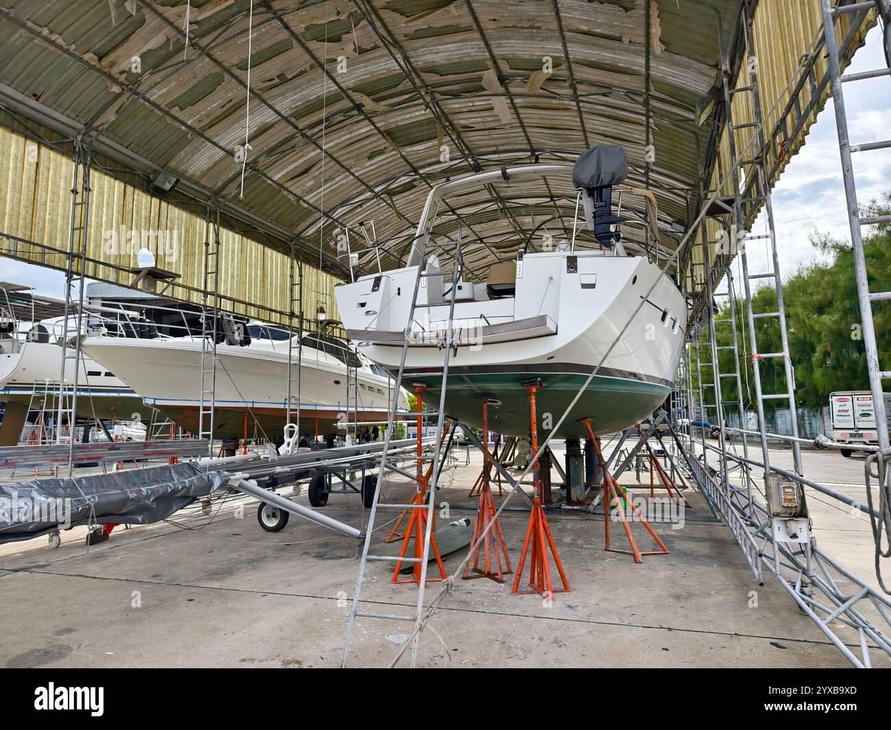 A boat is carefully lifted under a covered structure Stock Photo - Alamy