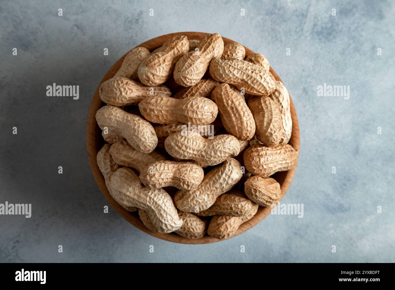 Bowl full of shelled peanuts on light blue background,top view Stock ...