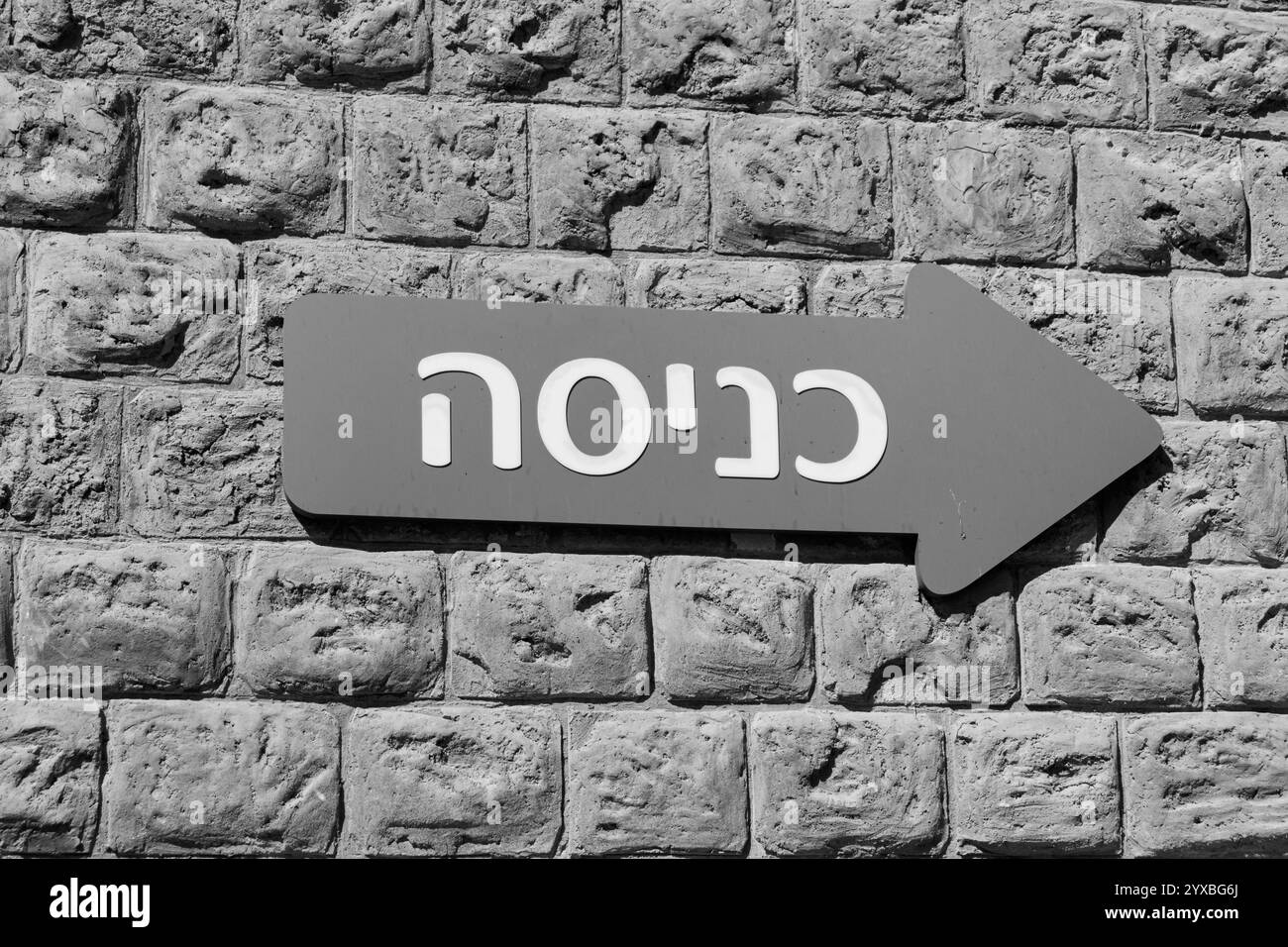 Green entrance arrow sign in hebrew leading to the storefront entrance ...