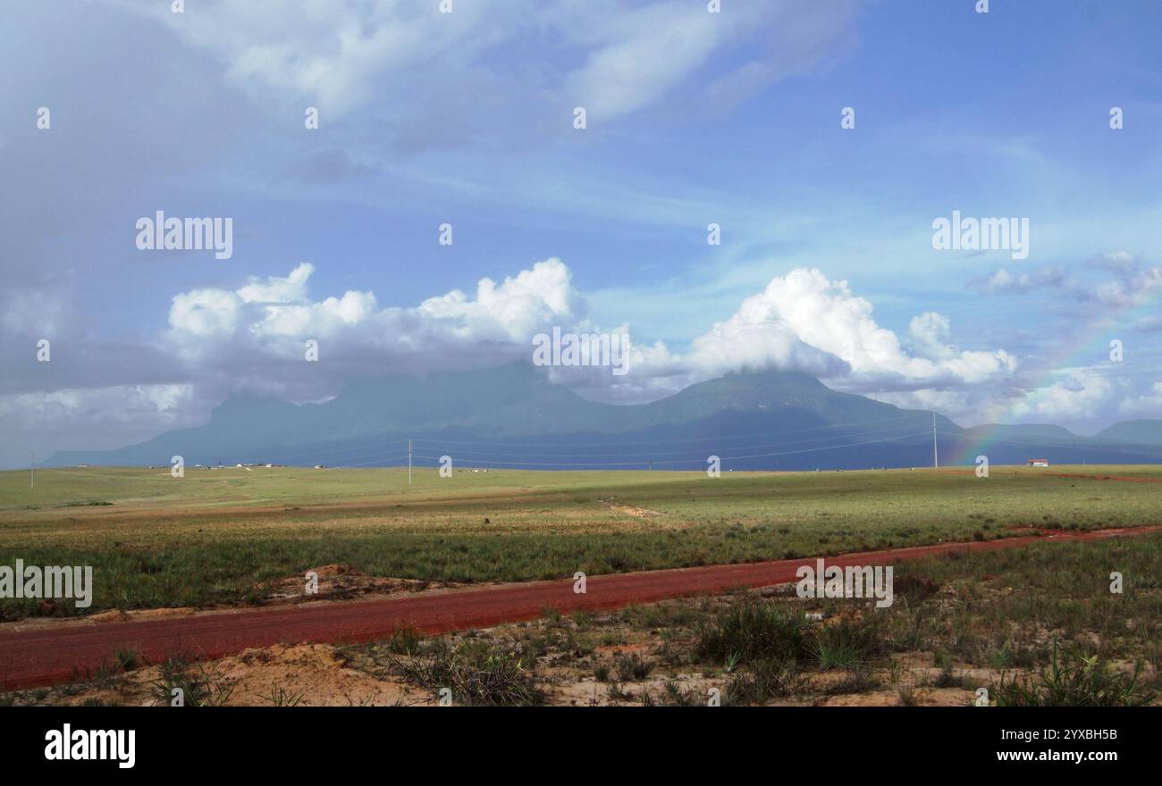 Rainbow view of dirt road and tepui mountains across savannah, Gran ...