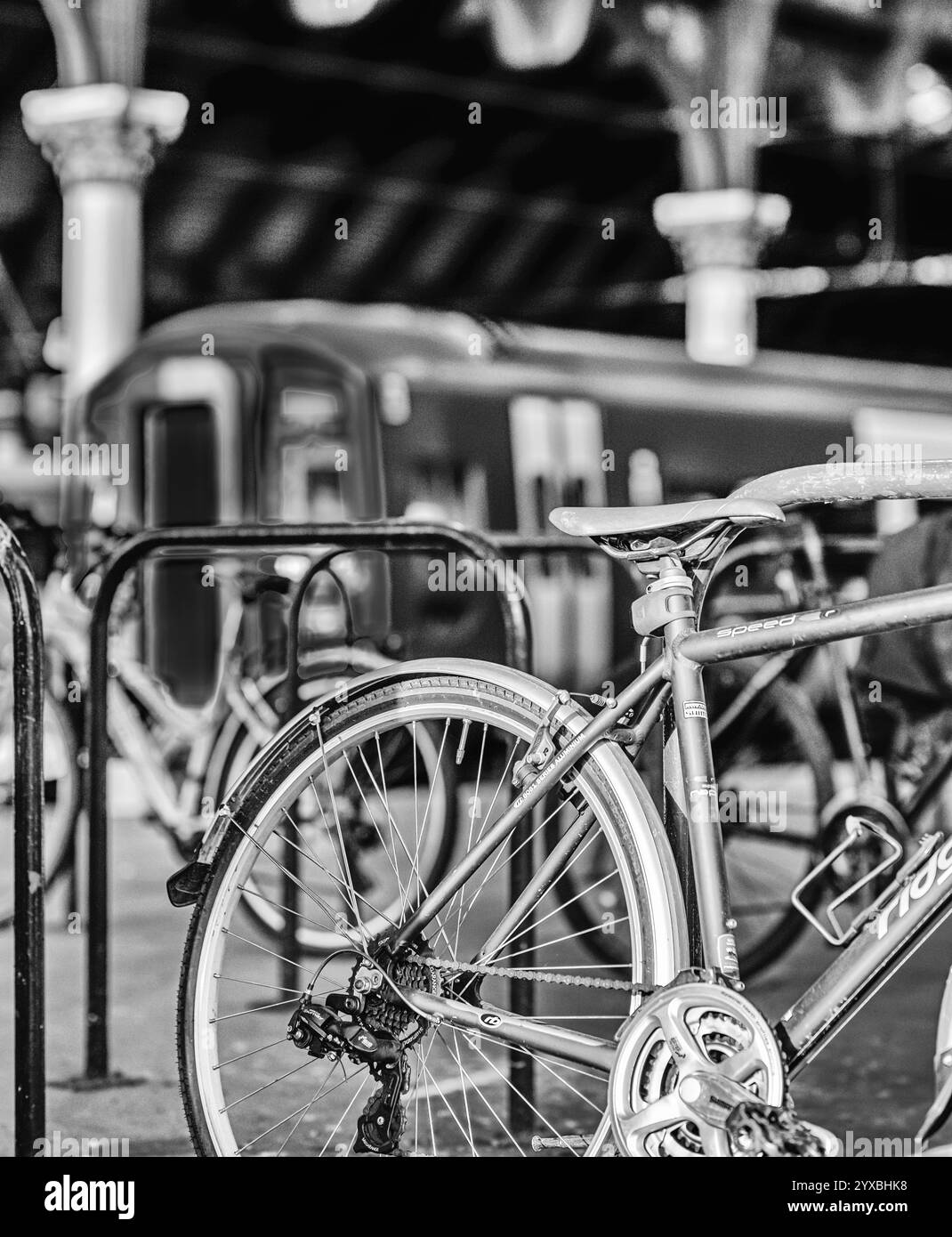 A bicycle is is standing on a railway platform fastened to a stanchion ...