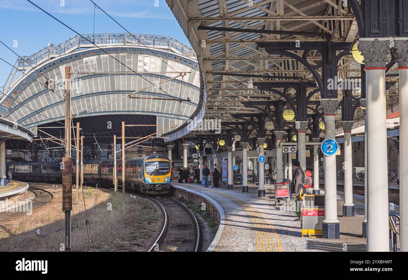A train comes to a stop at a railway station platform. An historic iron ...