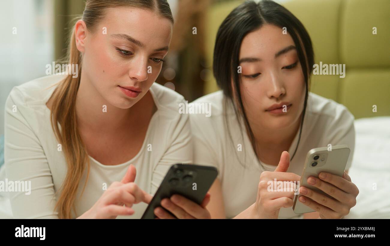 Two happy smiling multiracial friends multiethnic women diversity girls female Caucasian Asian ...