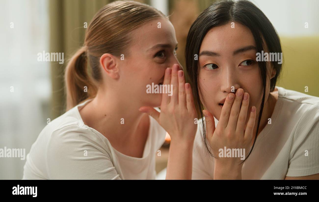 Multiracial friends women Caucasian woman whisper secret gossip talk ...