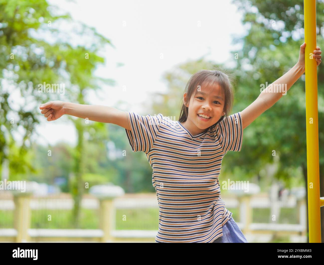 Cute girl having fun on the swing in the playground in the park ...