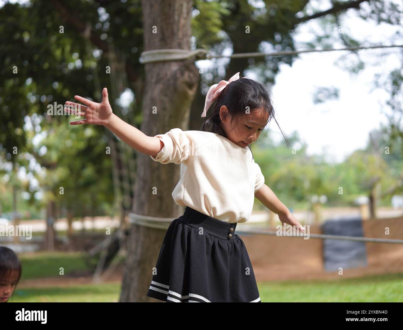 Cute little girl walking on balance beam in outdoor park. Children ...