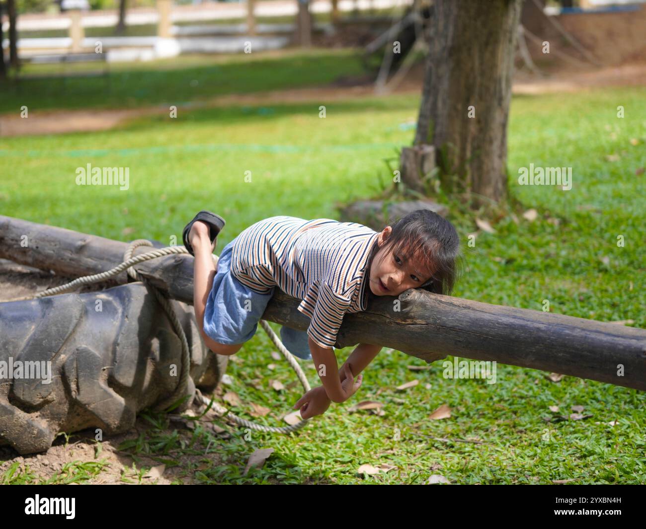 Cute little girl walking on balance beam in outdoor park. Children ...