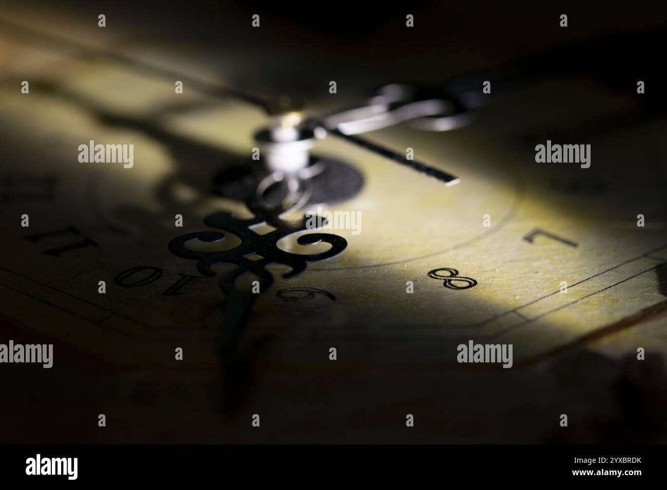time concept with a detail of an old clock illuminated by a beam of ...