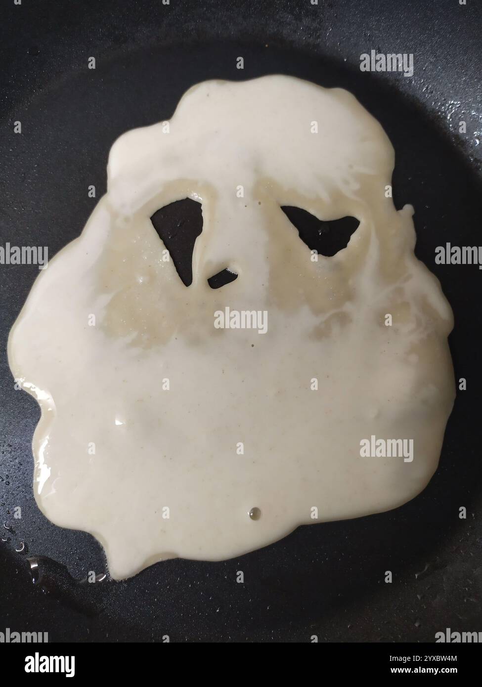 Liquid pancake batter with eyes in a pan undercooked in the kitchen ...
