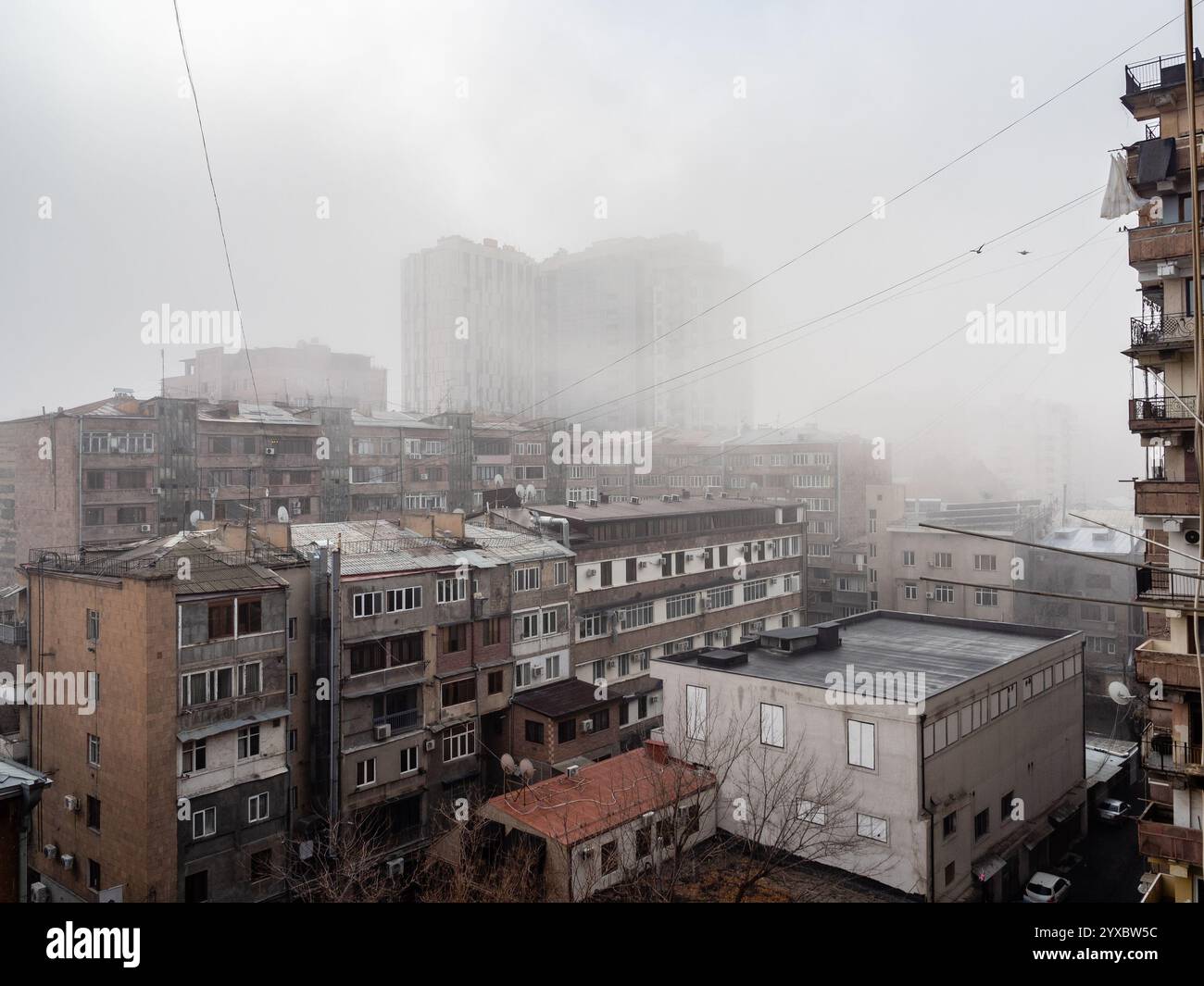 smoke, smog and fog over apartment buildings in Yerevan city in winter ...