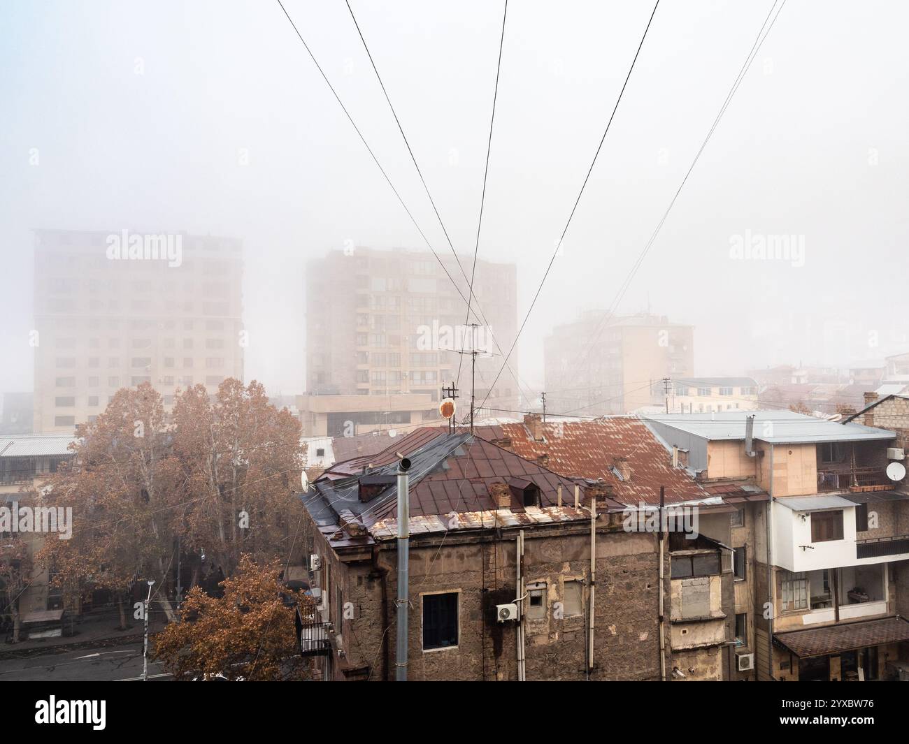 street in Yerevan city under smoke, smog and fog on rainy winter day ...