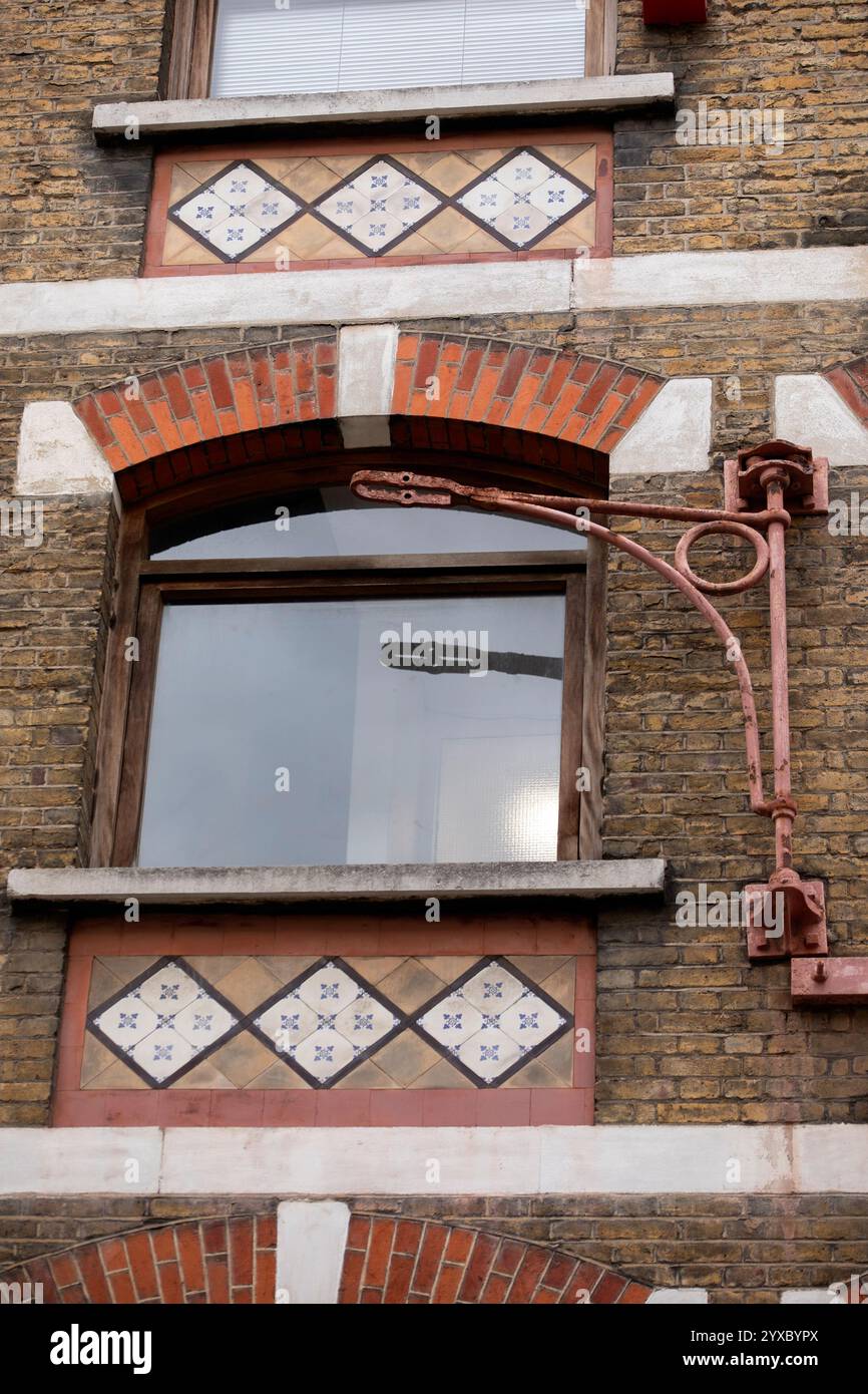 LONDON, UK - OCTOBER 22, 2021: Old wrought iron hoist and window with ...