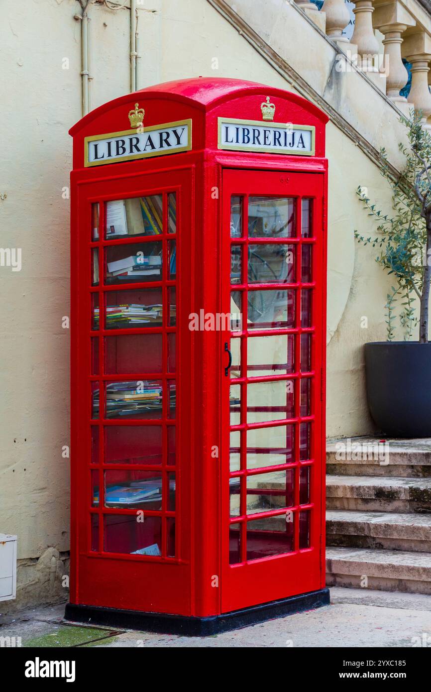 A vibrant red telephone booth was converted into a public mini library ...