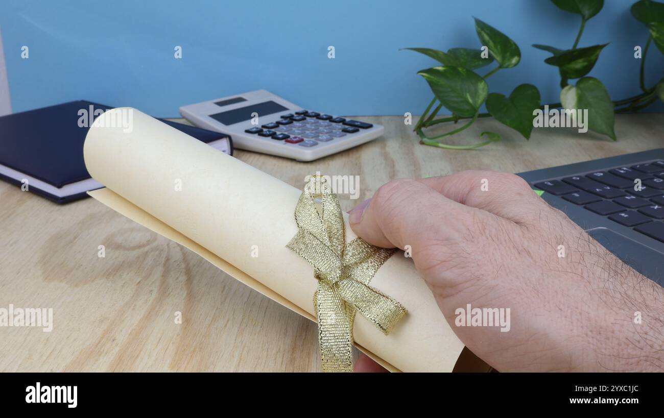 Man with hand showing a diploma or certificate, on school desk Stock ...