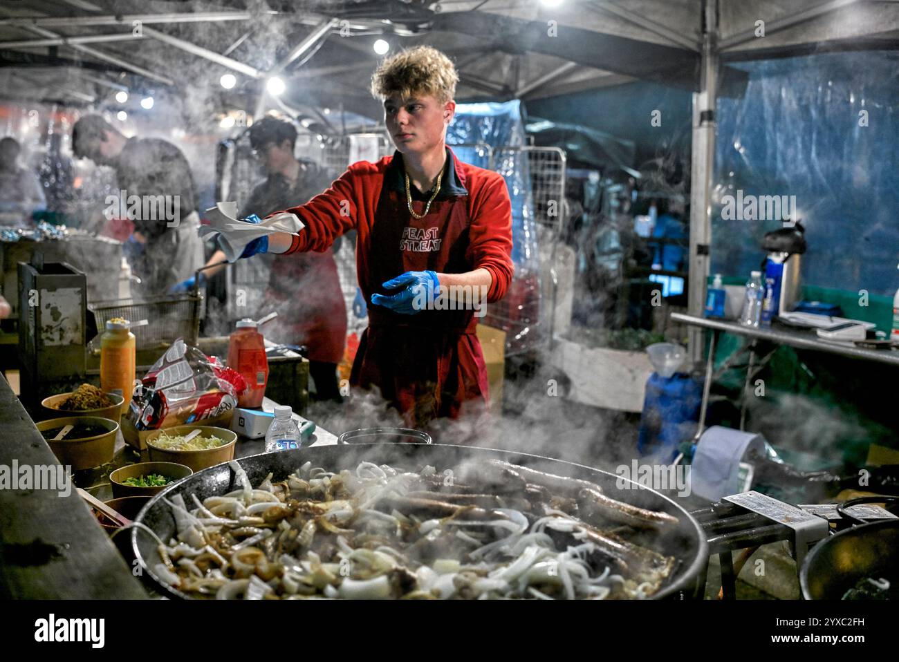 Chef cooking hot dogs and burgers at a street market, Stratford upon ...
