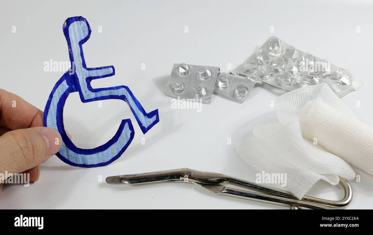 Man hand holds drawing of wheelchair with doctor's medical tools with ...