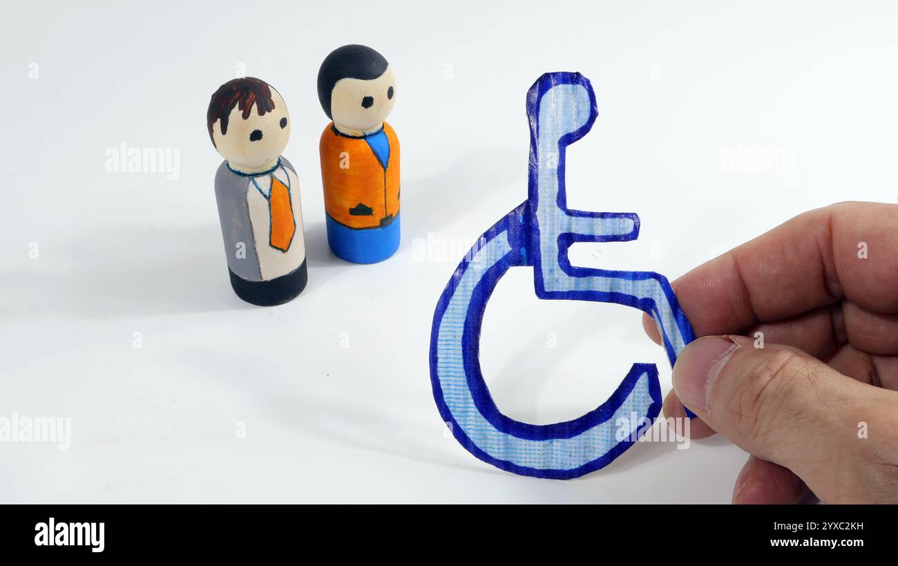 Two wooden mannequins look at a wheelchair, a symbol of personal disability and illness Stock ...