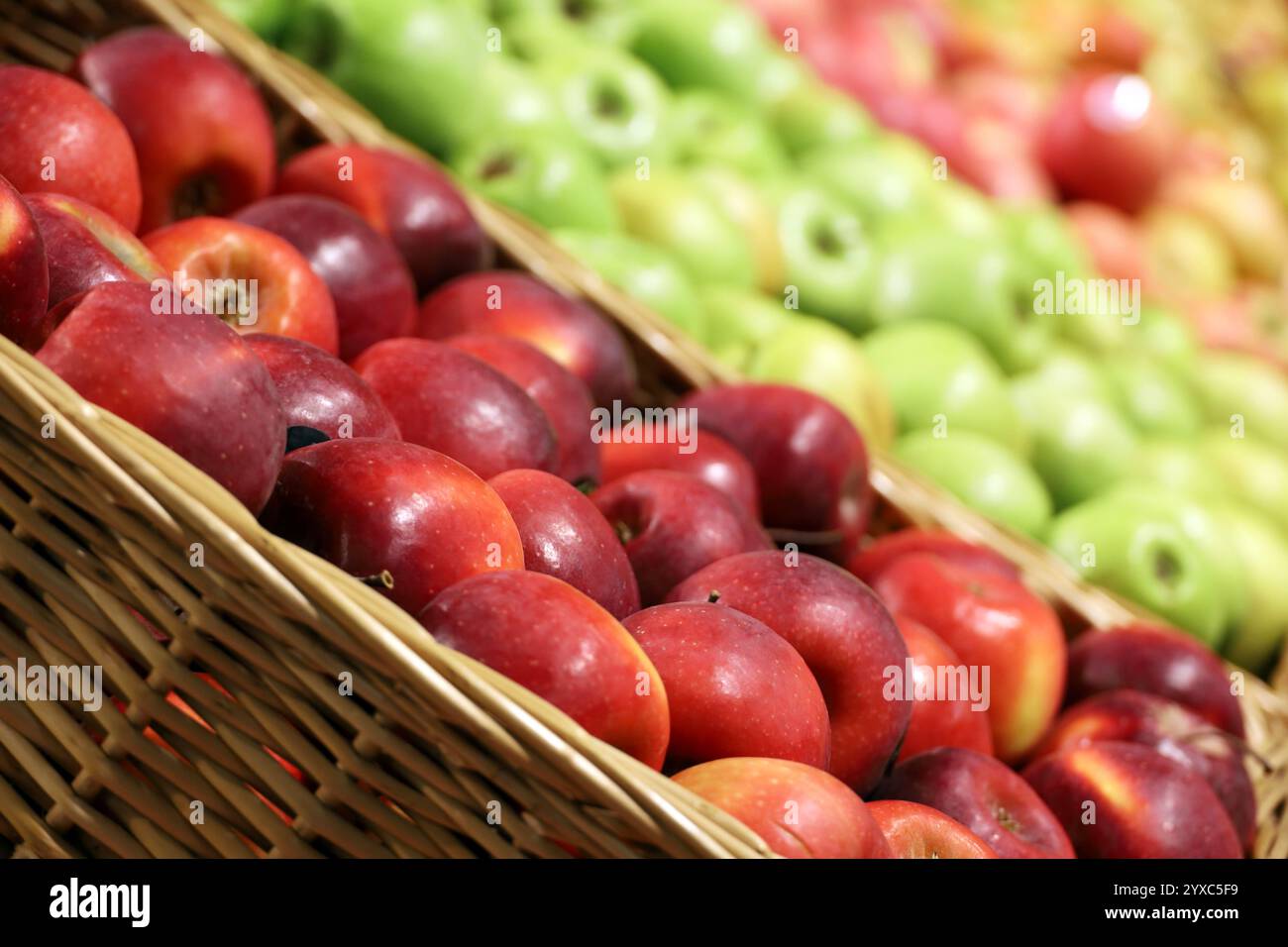 Red and green apples in a wicker baskets. Fresh harvest, ripe fruits in ...