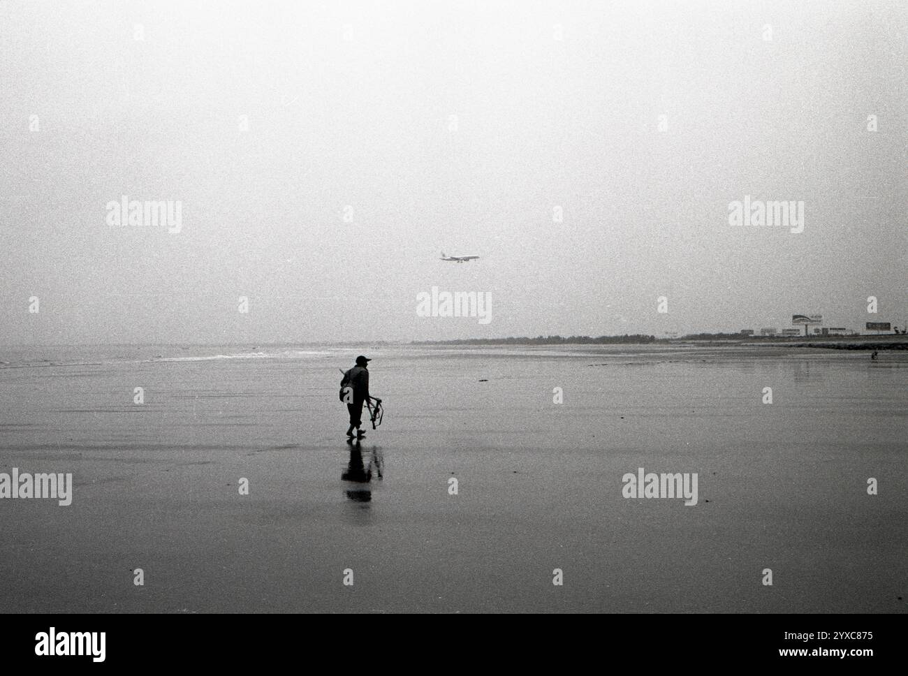 A beach near Fuzhou Changle Airport in China, with a landing airplane ...