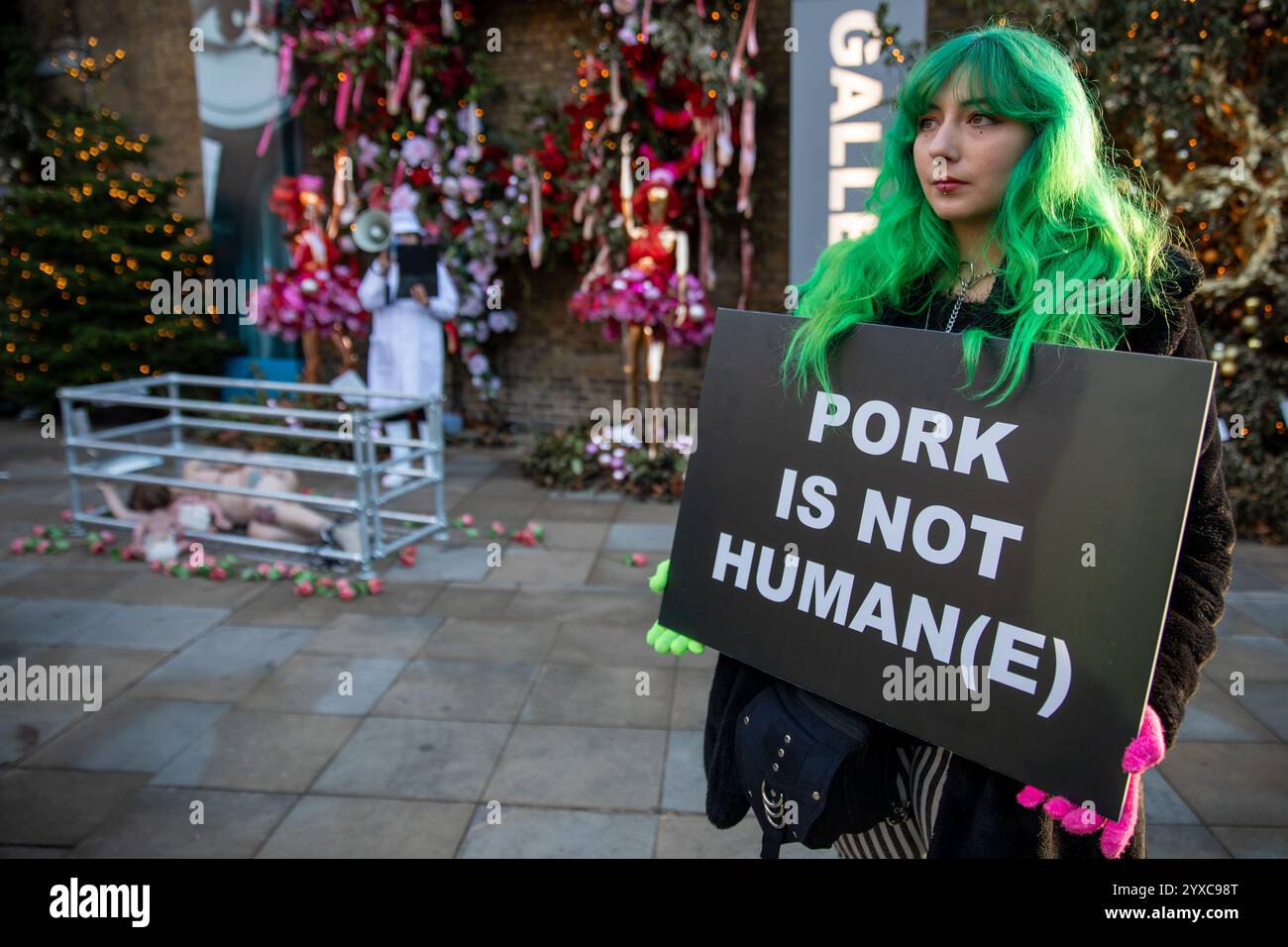 An animal rights activist holds a protest sign amidst the demonstration ...