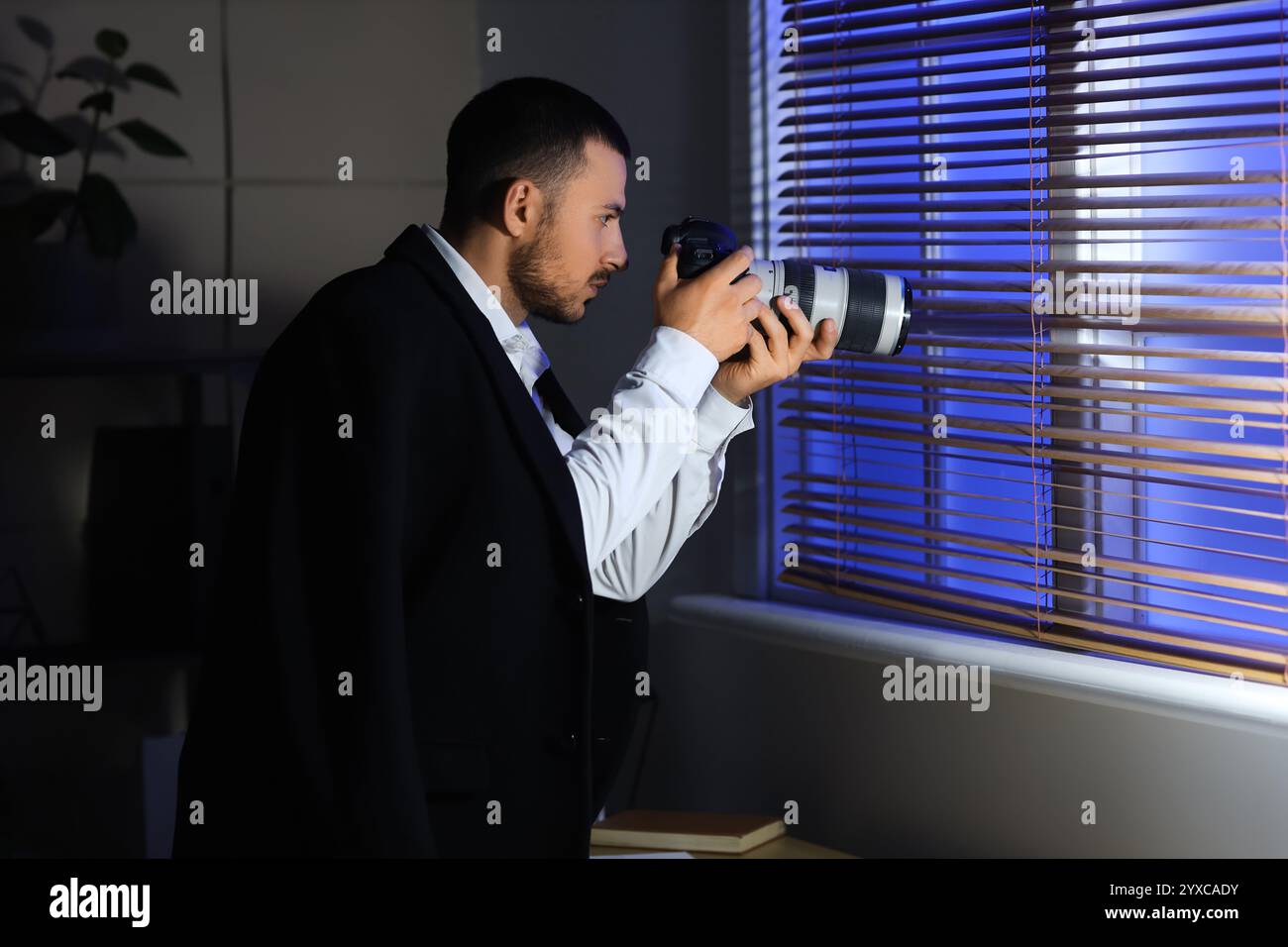 Male detective taking pictures near window in room at night Stock Photo ...