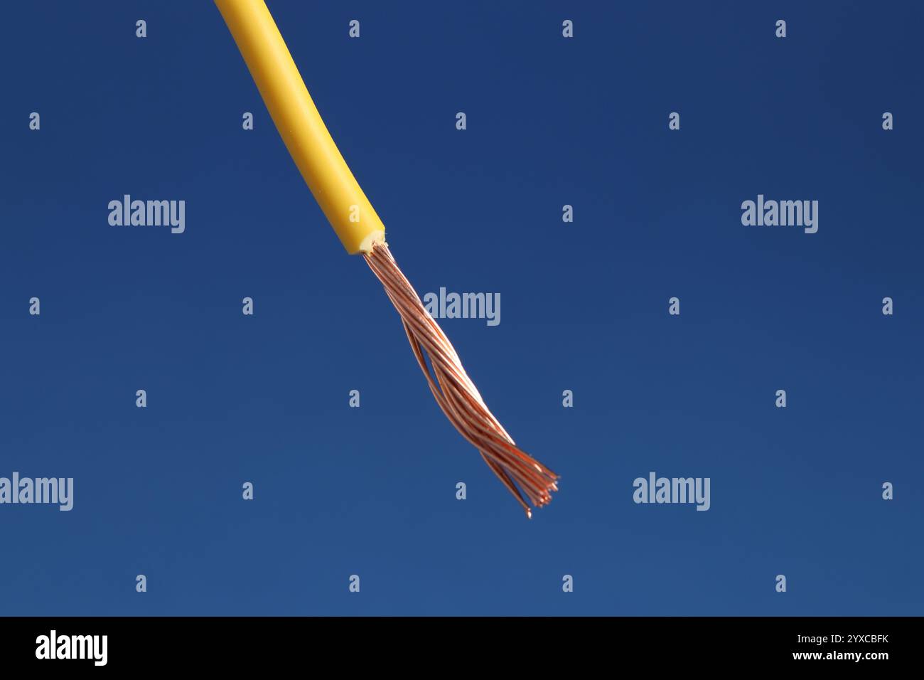 Yellow stripped electrical wire on blue background, closeup Stock Photo ...