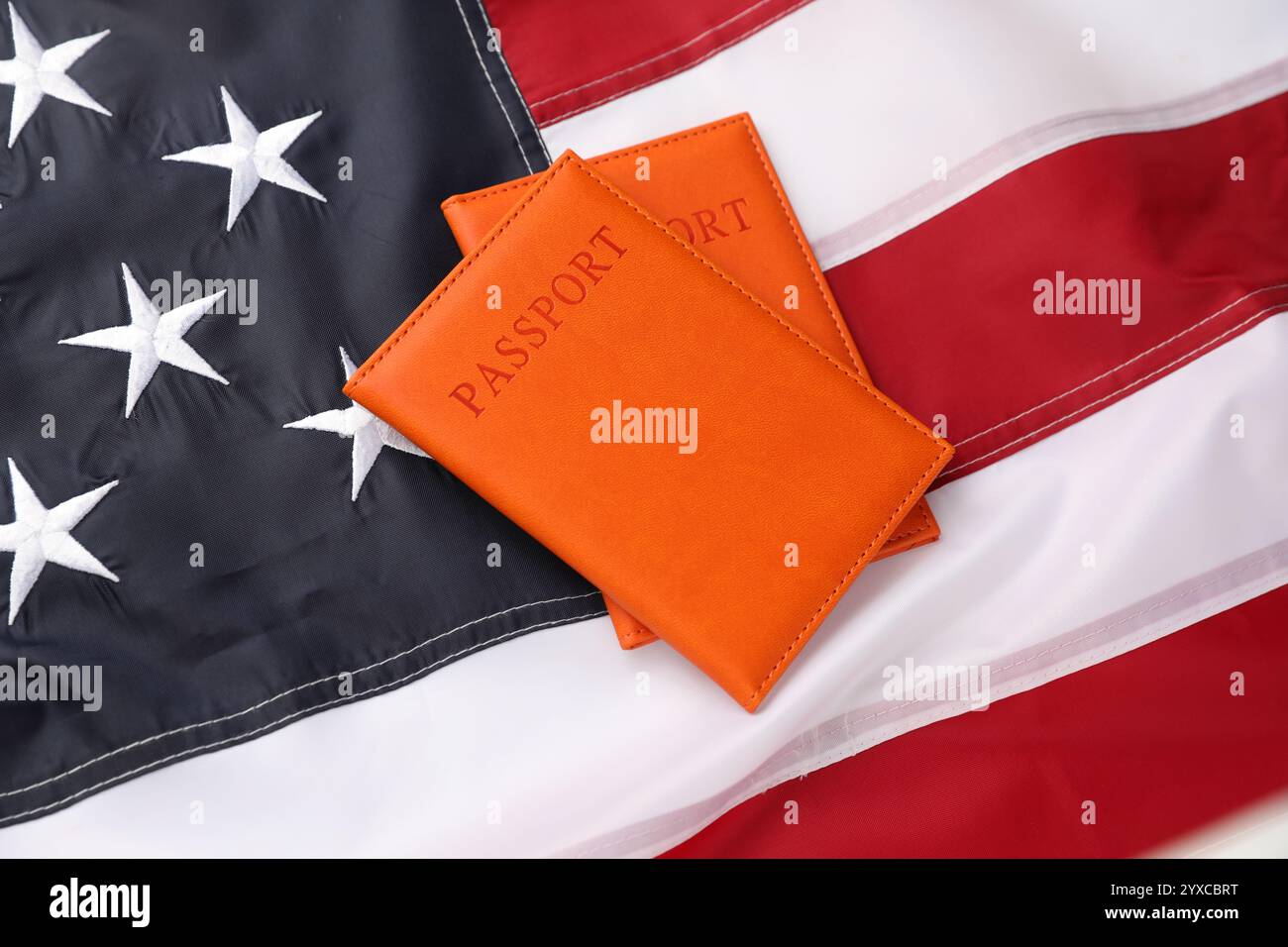 Passports in orange covers on flag of United States, above view Stock ...