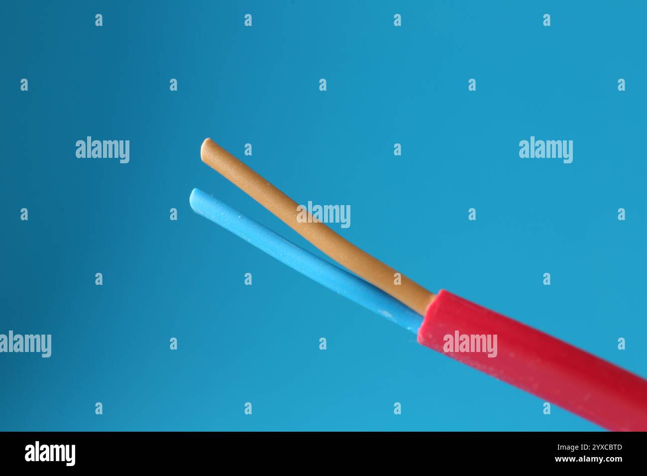 Red stripped electrical wire on light blue background, closeup Stock ...