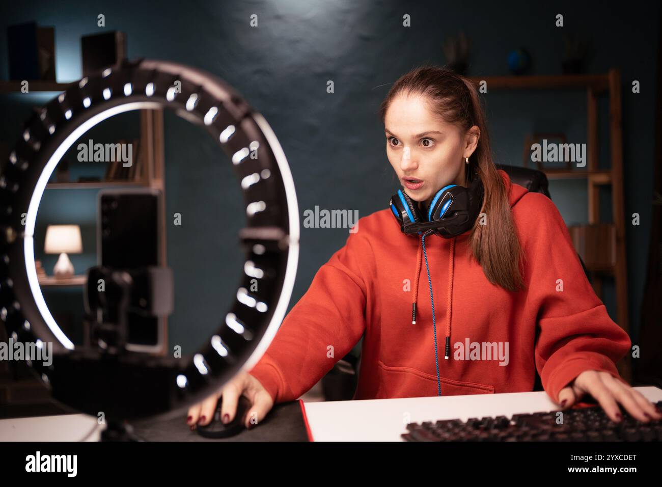 Shocked female gamer streamer live streaming using ring light with ...