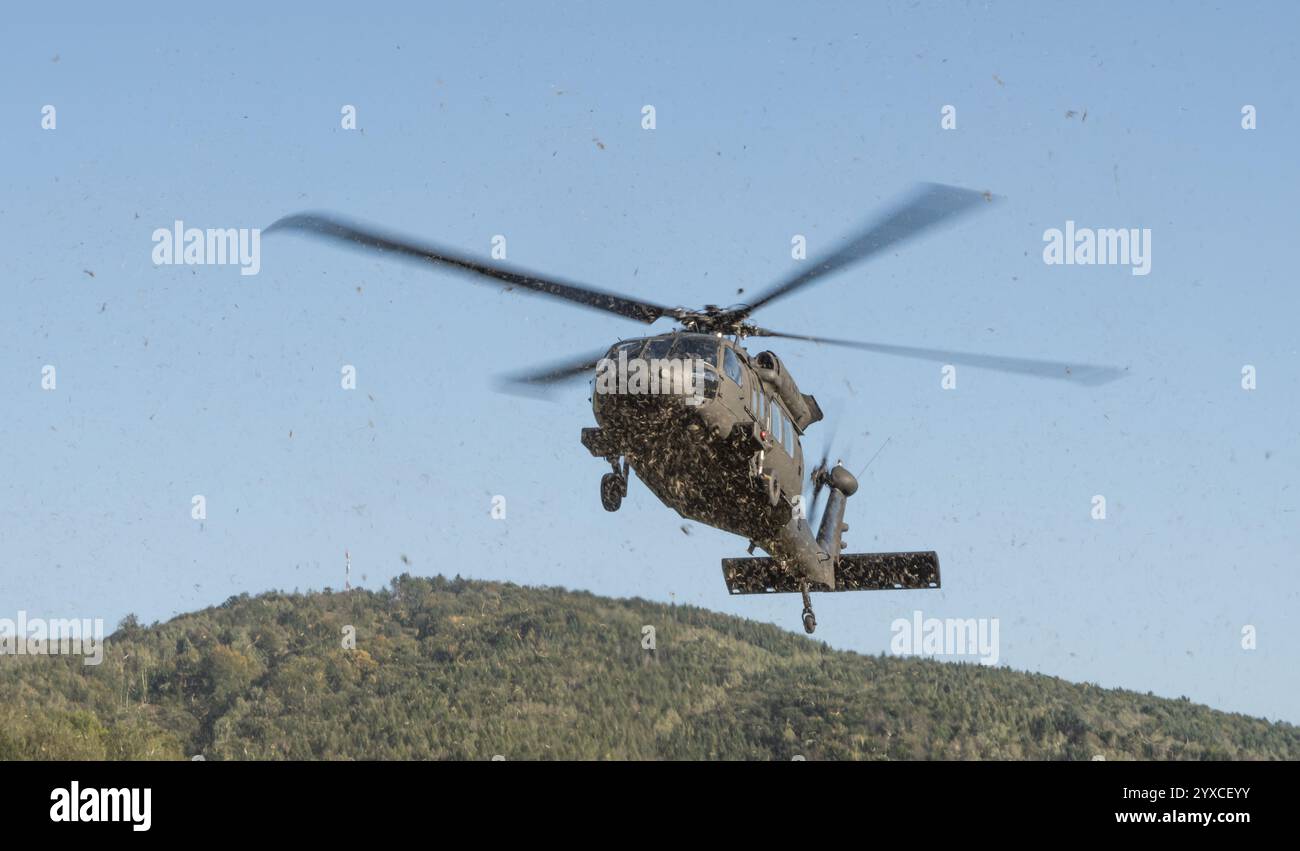 A Sikorsky UH-60M Black Hawk helicopter takes off, raising grass dust ...