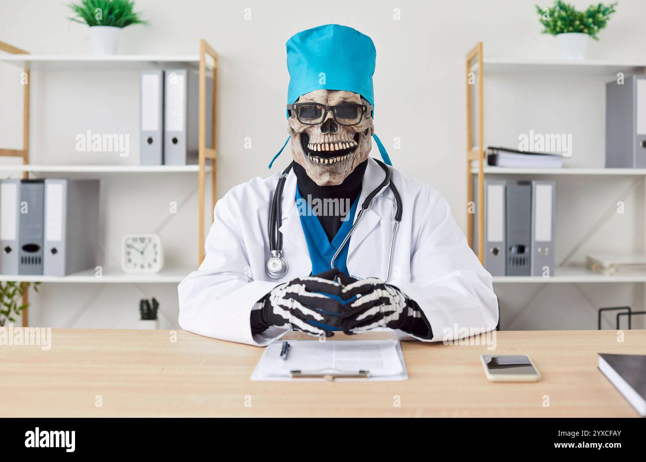 Male doctor death in scull skeleton mask sitting at the desk on ...