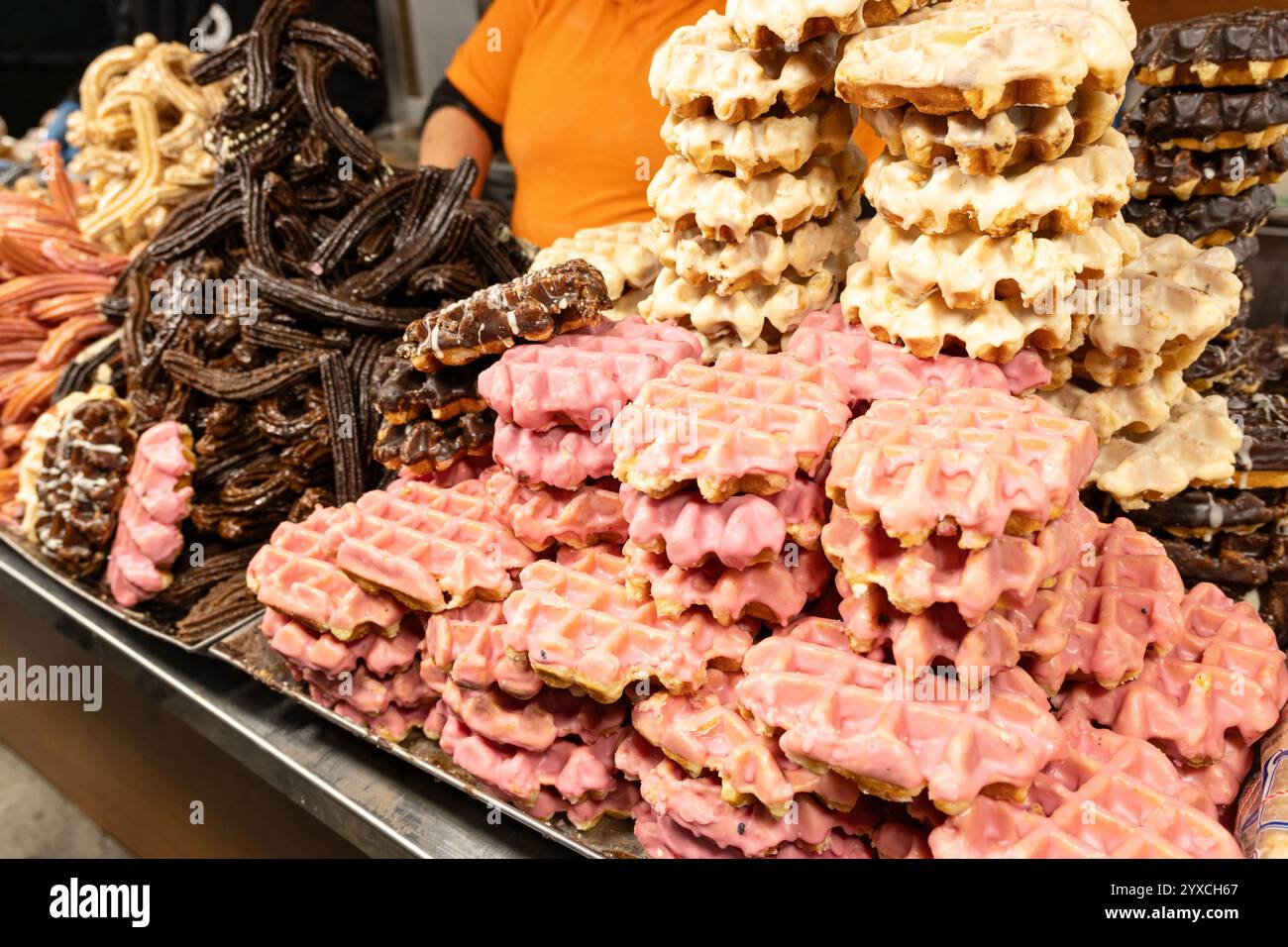 Close-up of a stack of chocolate-covered waffles and churros at a ...