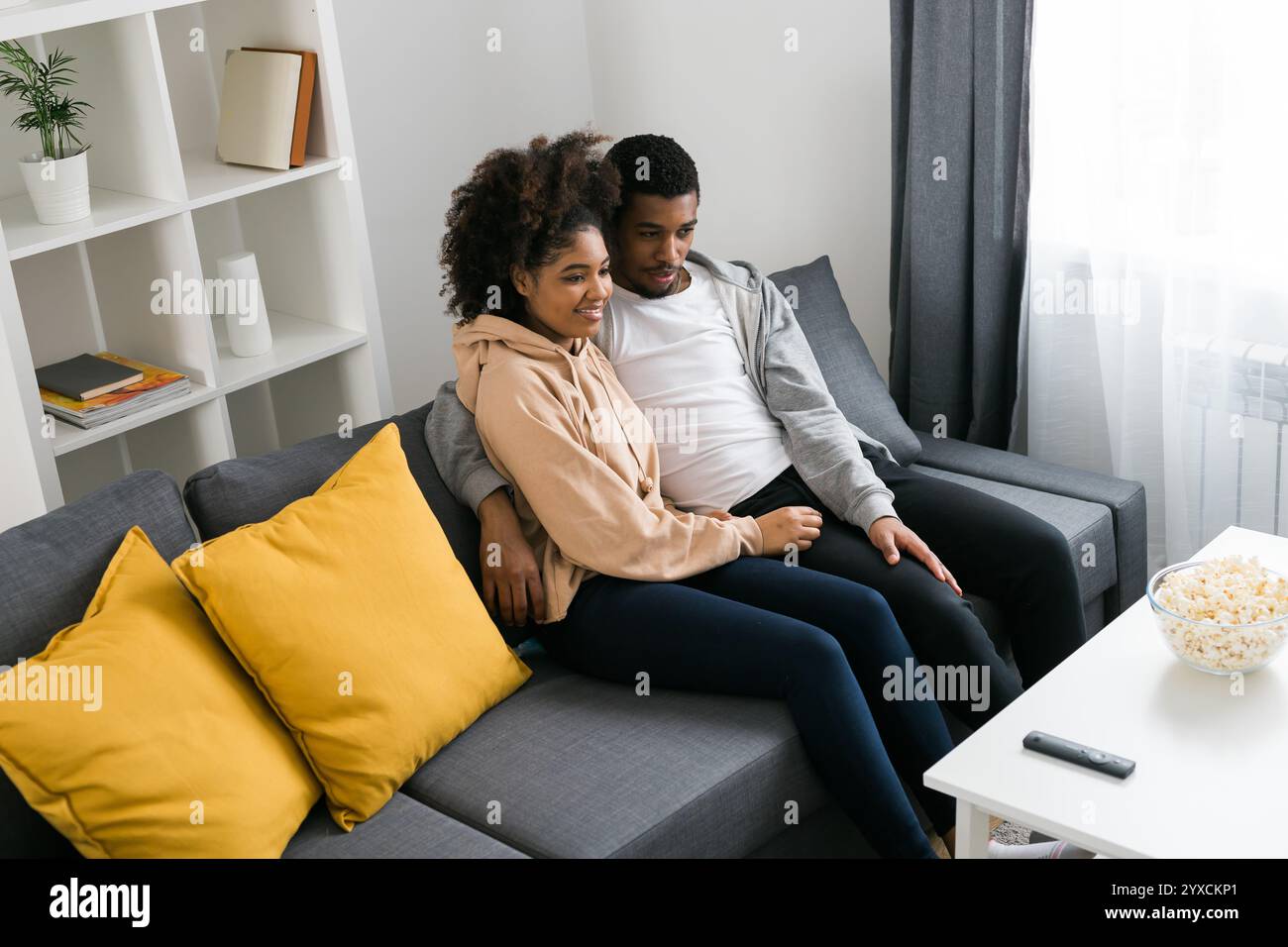 African American couple wife husband watching movie. Family pastime and leisure, watch ...