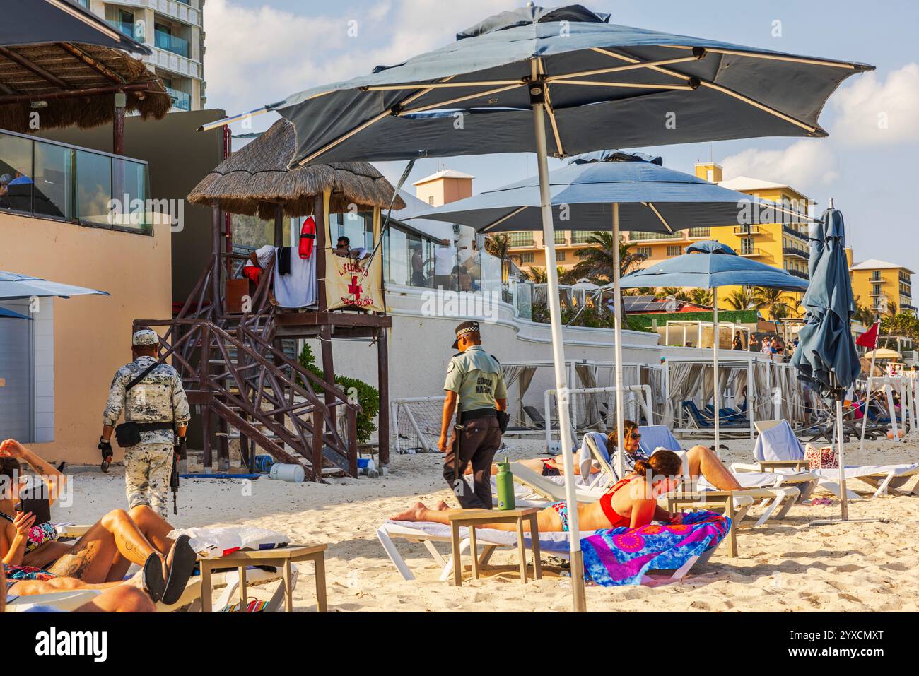 Soldiers and police patrol beach near lifeguard tower, ensuring safety ...