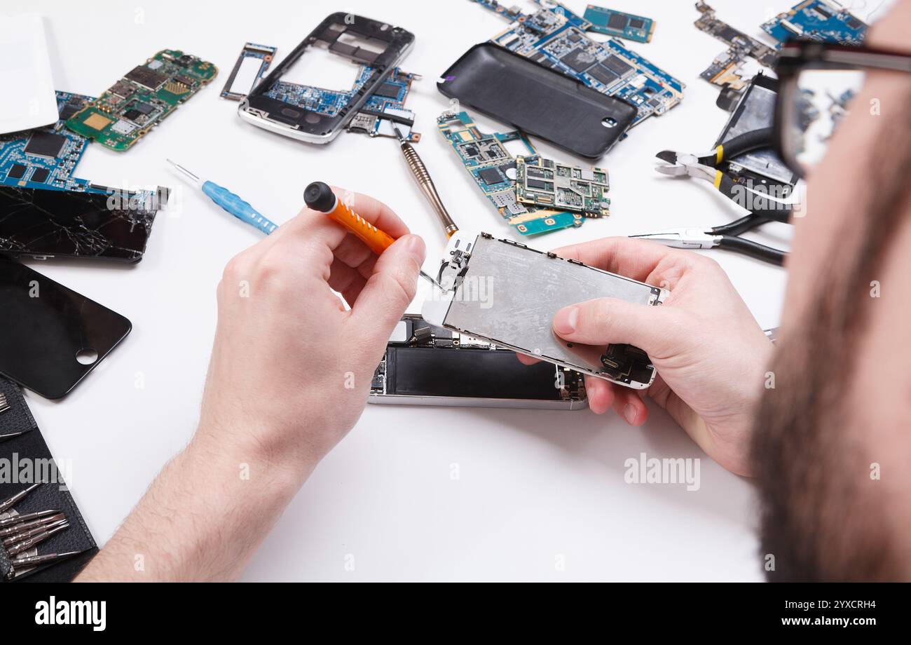 Repairman disassembling phone with screwdriver Stock Photo - Alamy
