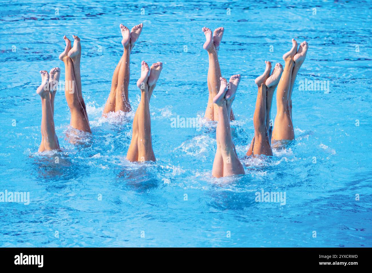 Artistic swimming team performing synchronized legs choreographed ...