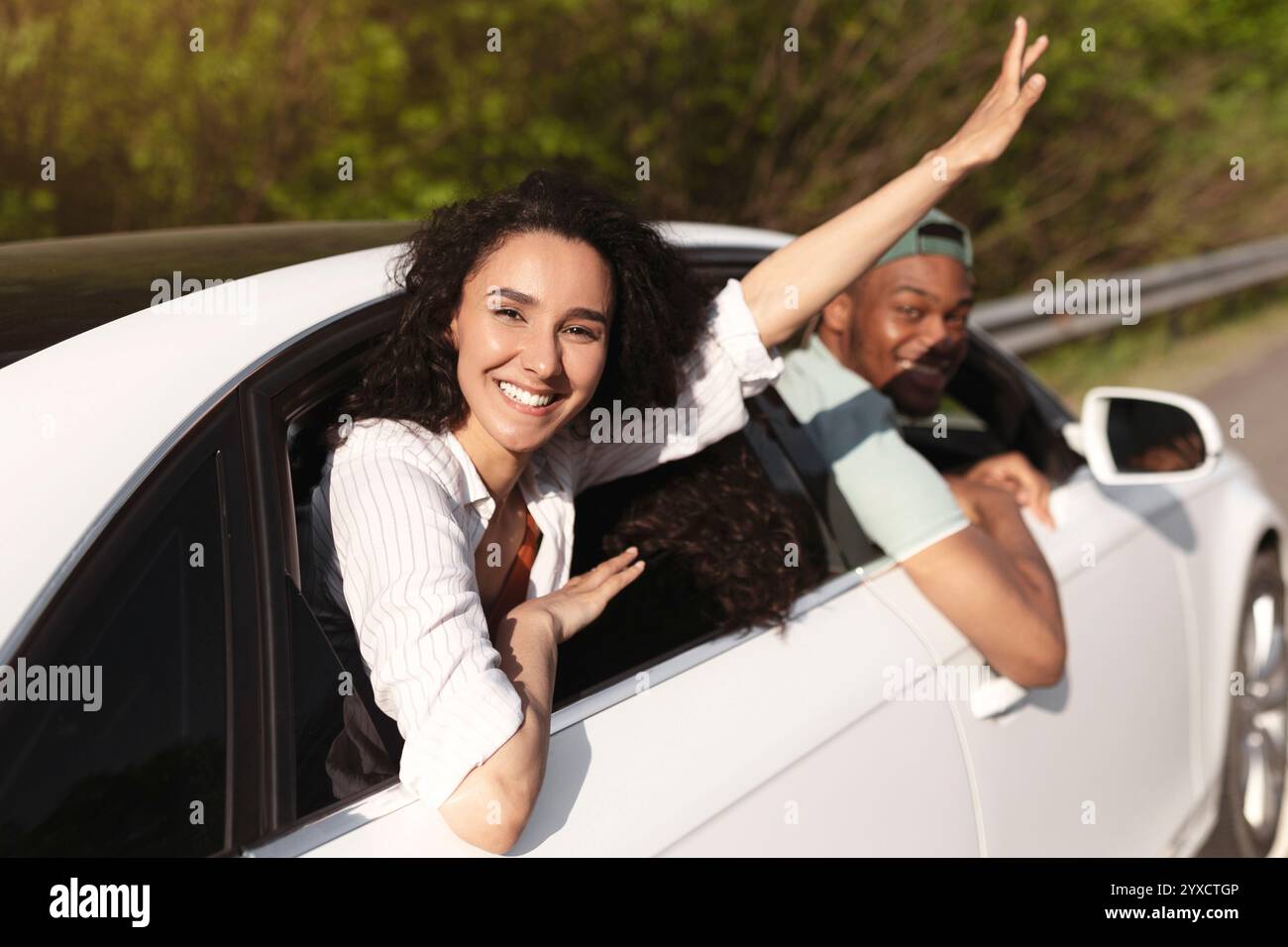 Multiracial best friends traveling together by car, looking through ...