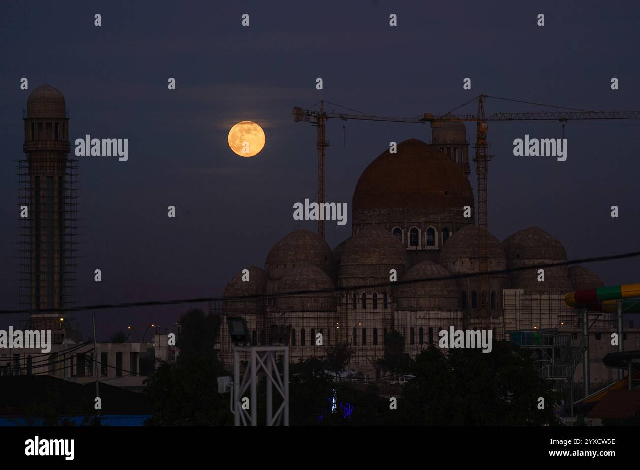 The full moon rises behind the Great Mosul Mosque in the northern Iraqi ...