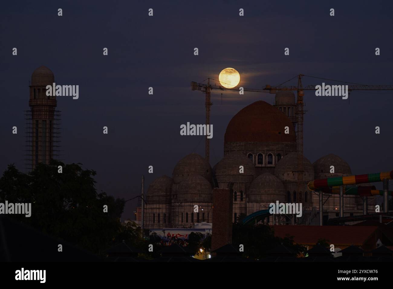 The full moon rises behind the Great Mosul Mosque in the northern Iraqi ...