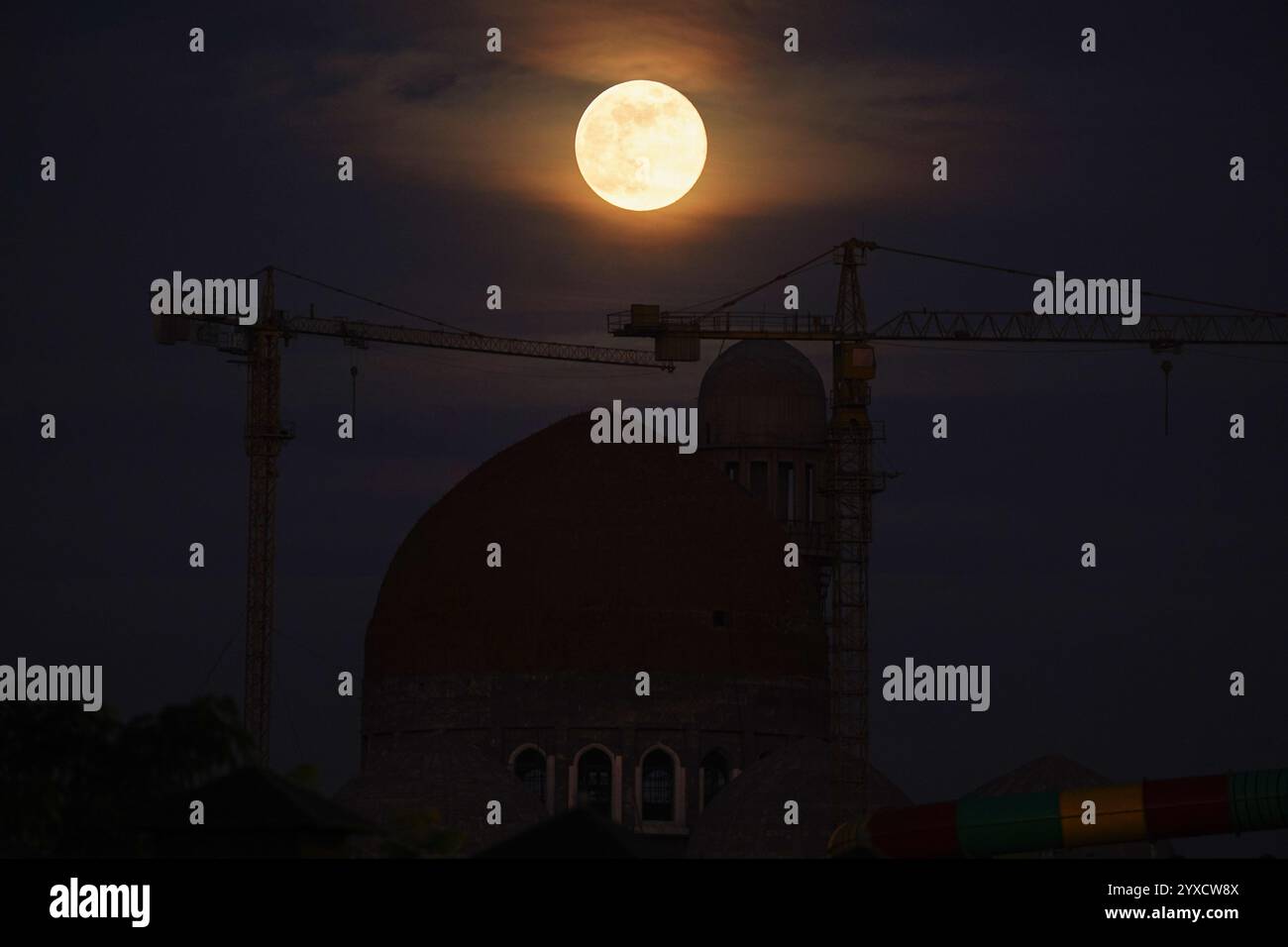 The full moon rises behind the domes of the Great Mosul Mosque in the ...