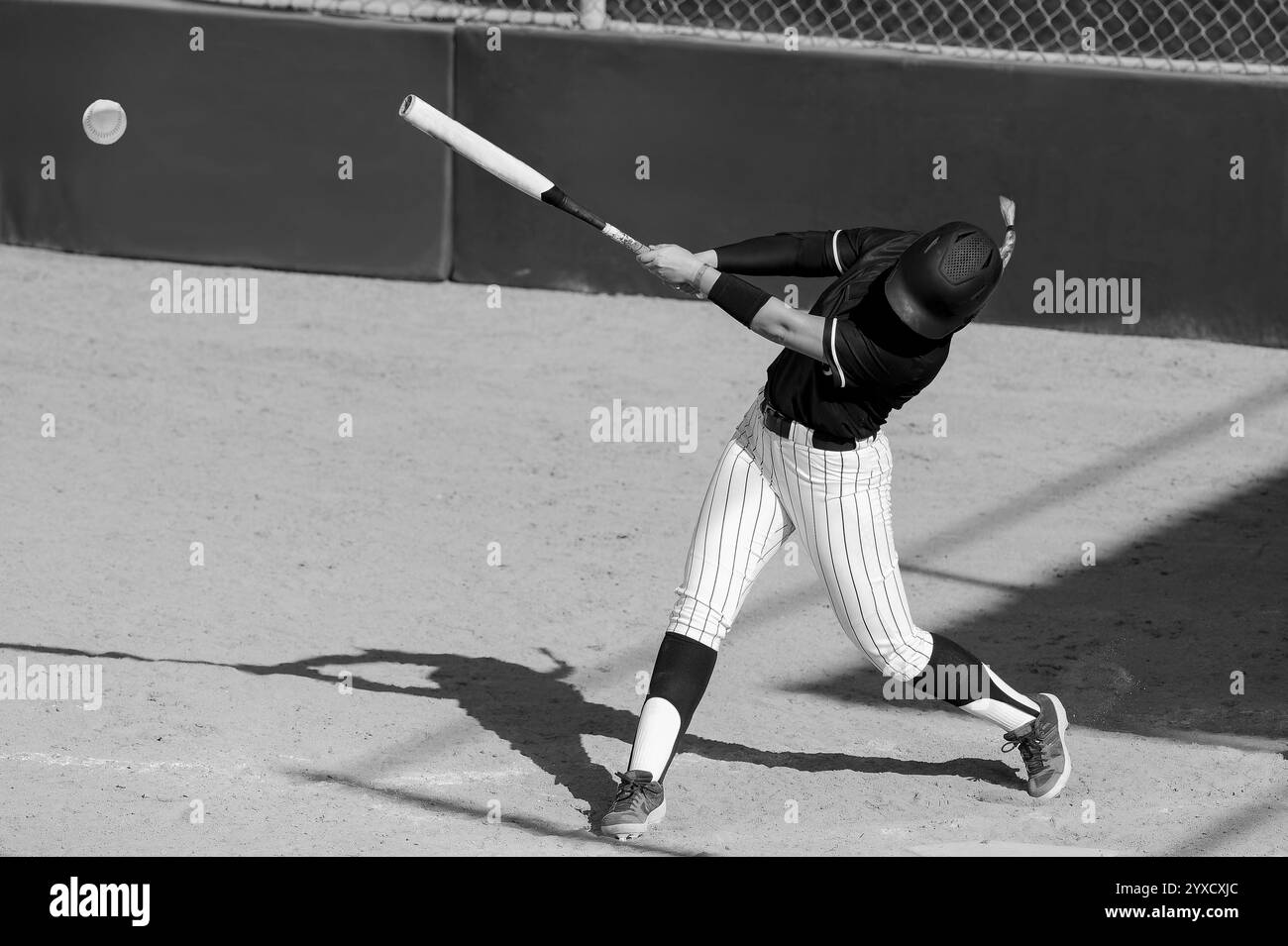 A Softball Player Is Swinging The Bat To Make Contact With The Baseball Black And White Image ...